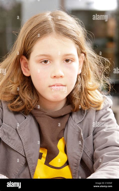 Boy 10 Years Old With Long Hair Looking Into The Camera Stock Photo