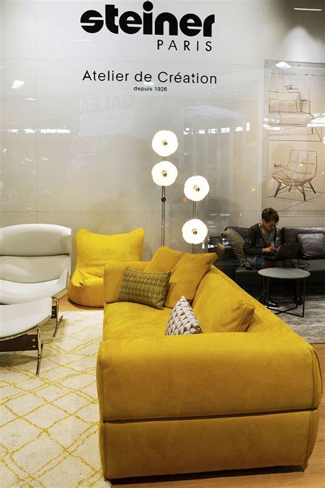 A Man Sitting On A Couch In Front Of A Wall With The Name Steiner Paris
