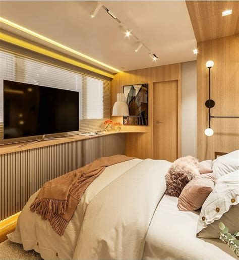 A Bedroom With A Large Flat Screen Tv Mounted On The Wall Above It S Bed