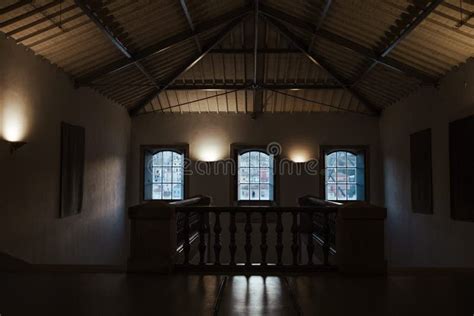 Interior Of A Dimly Lit Empty Room With Wooden Staircase Stock Photo
