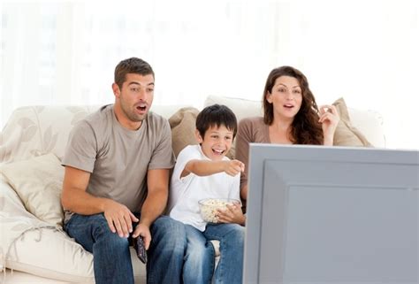Familia feliz viendo una película en la televisión juntos en el sofá