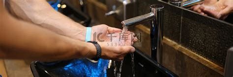 男人在家里浴室的水槽里洗手用手触摸自来水检查温度高清摄影大图 千库网