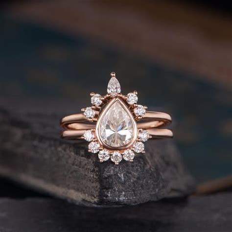 An Engagement Ring With A Pear Shaped Morganite Surrounded By Small