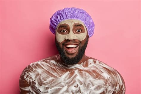Free Photo Positive Naked Gentleman Wears Facial Mask Has Foam On Body Enjoys Taking Shower