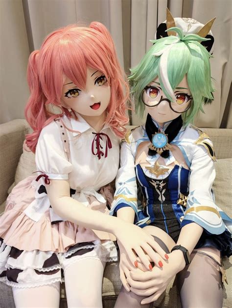 Two Dolls Sitting Next To Each Other On A Couch