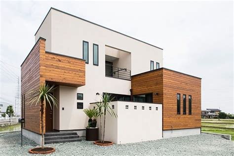 A Modern House With Wood And White Sidings On The Outside Along With