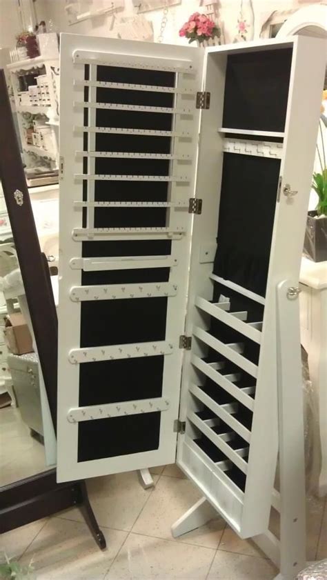 A Large White Cabinet With Many Drawers On It S Sides And Two Mirrors