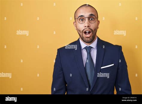 Hispanic Man With Beard Wearing Suit And Tie Afraid And Shocked With