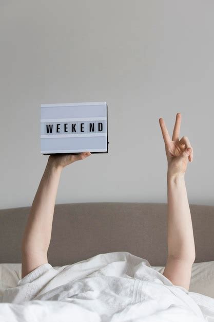 Premium Photo Female In Bed Under The Sheets Holding A Weekend Sign