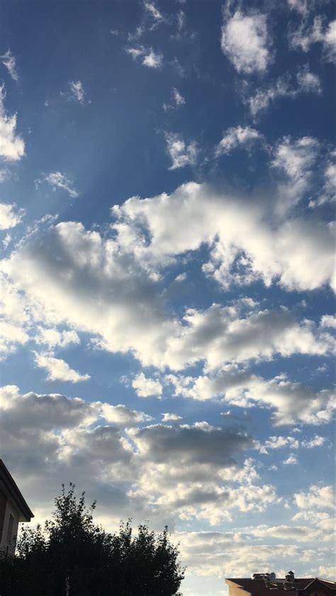 The Sky Is Full Of Clouds And Some Buildings
