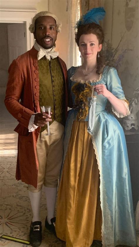 A Man And Woman Dressed In Period Costumes