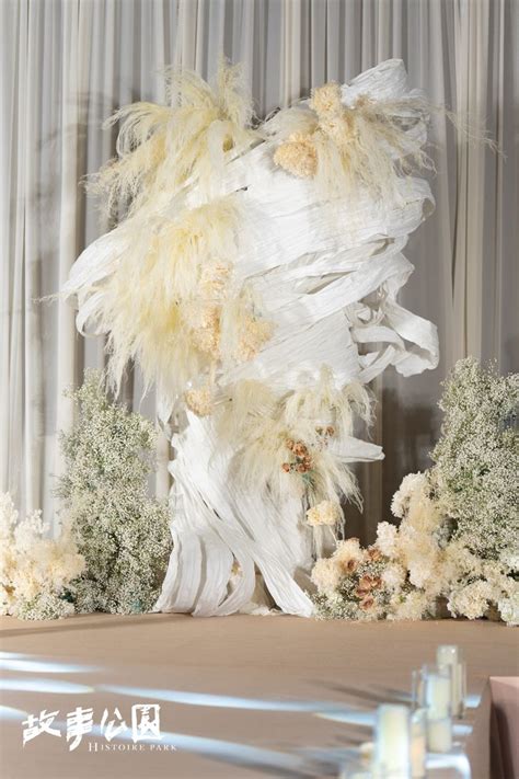 An Elaborately Decorated Table With White Flowers And Feathers