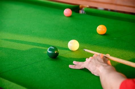 Mão do homem jogando sinuca no bar bola de snooker Foto Premium