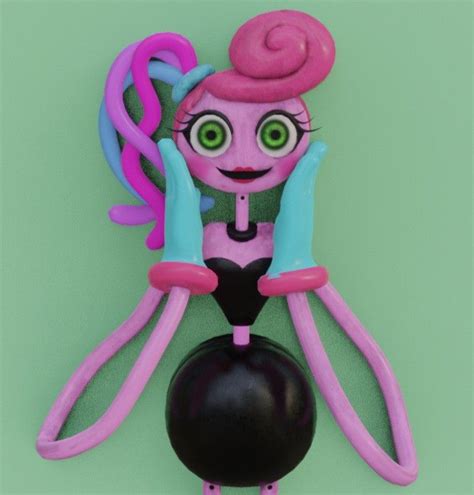 A Pink And Blue Toy With Green Eyes On Top Of A Black Ball In Front Of