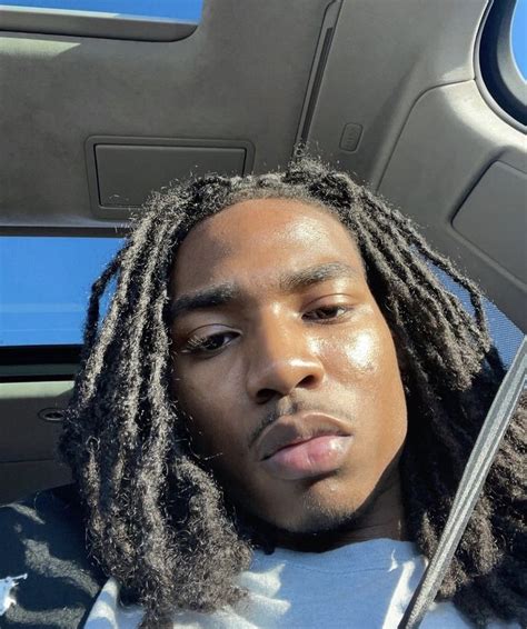 A Man With Dreadlocks Sitting In The Back Seat Of A Car