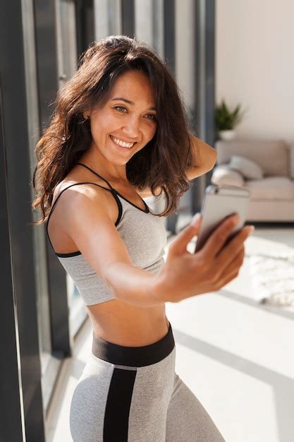 Mujer En Forma De Tiro Medio Tomando Selfie Foto Gratis
