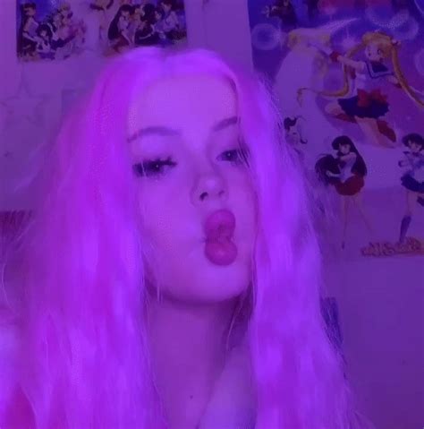 A Woman With Pink Hair Is Making A Face And Sticking Her Tongue Out To The Side