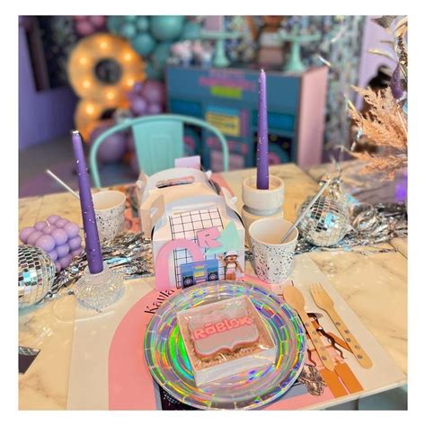 A Table Set For A Birthday Party With Candles And Plates On It Along