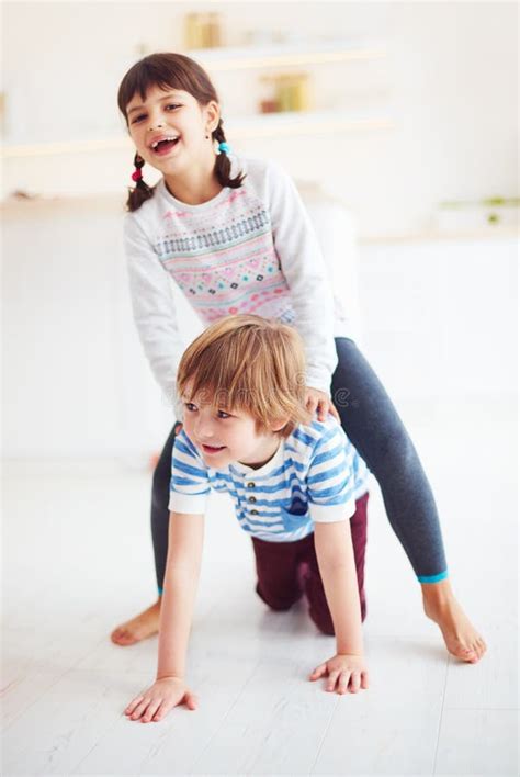 Enfants Enthousiastes Ayant L Amusement Sur Le Terrain De Jeu Gonflable