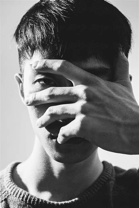 Closeup Portrait Of An Asian Man Covering His Face Black And White