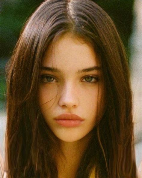 A Close Up Of A Person With Long Brown Hair And Blue Eyes Wearing A
