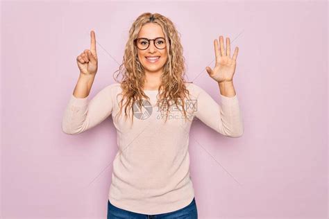 身穿散装毛衣和眼镜的金发美女在粉红色背景展上露面用六指头着6号手指微笑高清图片下载 正版图片503902364 摄图网
