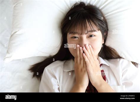 Portrait Japanese School Girl Uniform Sleep And Look At Camera In White Tone Bed Room Stock