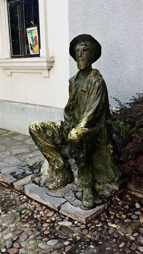 A Bronze Statue Sitting On Top Of A Stone Slab