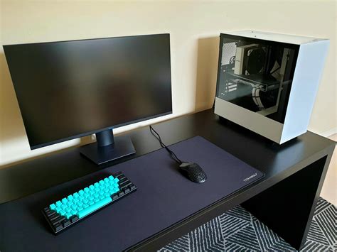a desk with a keyboard mouse and monitor on it in front of a wall