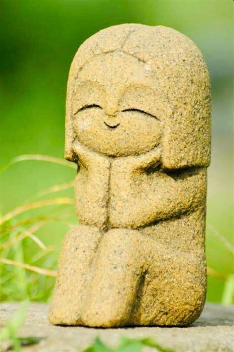 A Stone Statue Sitting On Top Of A Rock