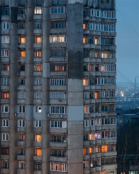 An Apartment Building With Many Windows Lit Up At Night