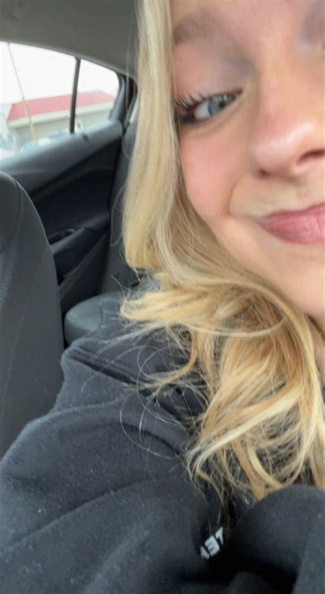 A Woman Sitting In The Back Seat Of A Car With Her Eyes Closed And Smiling