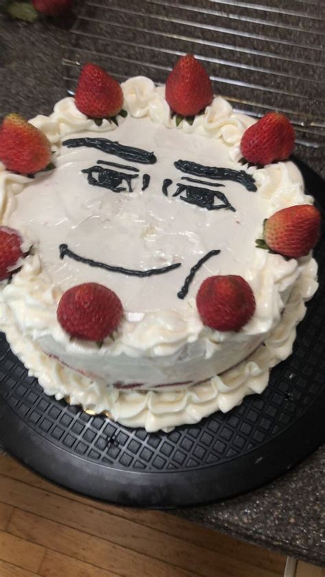 A Cake With Strawberries On Top Of It Sitting On A Counter Next To A Knife