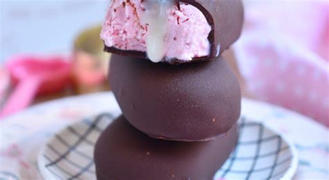 Helados bombón de fresa cubiertos de chocolate y rellenos de leche