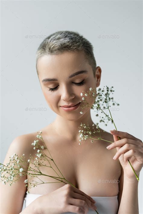 Pretty Woman With Naked Shoulders And Closed Eyes Smiling Near Branches