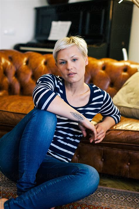 Portrait Of A Beautiful Blonde Woman Sitting In Front Of The Sofa At
