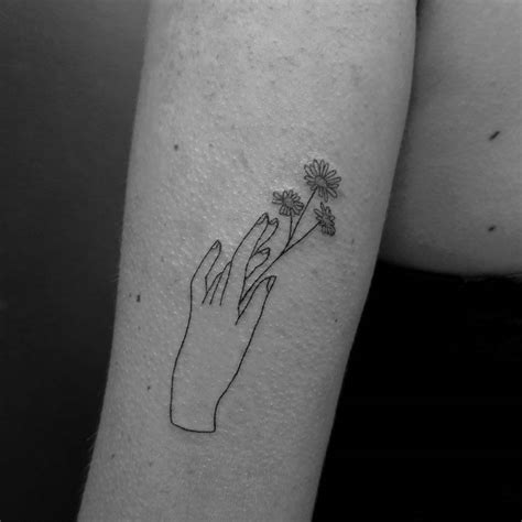 Hand Poked Hand Holding Flower Tattoo Located On The