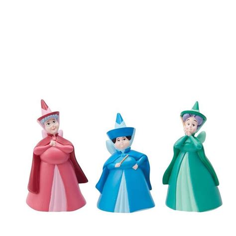 Three Small Figurines In Different Colors On A White Background