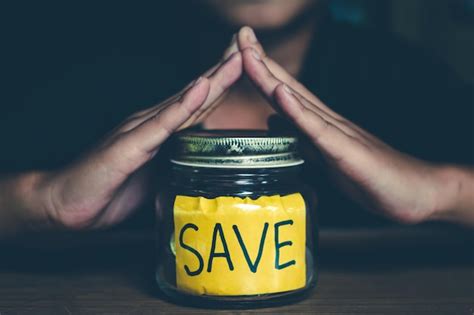 Premium Photo Midsection Of Person Holding Jar With Save Message On Table