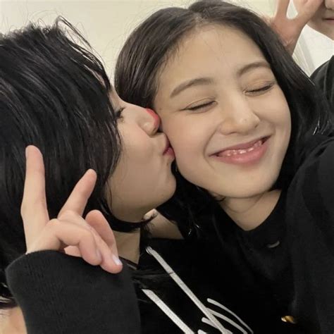 Two Girls Are Kissing Each Other While One Girl Is Holding Her Hand Up To Her Face