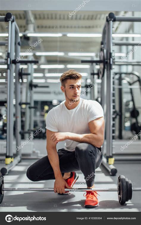 Attrayant bodybuilder blond torse nu en short à l intérieur dans la