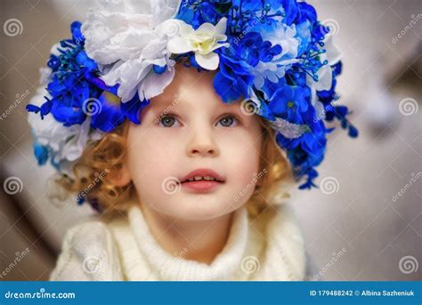 Close Up Portrait Of Small 4 Years Old Blonde Curly Girl In Warm Sweater And Big Artificial