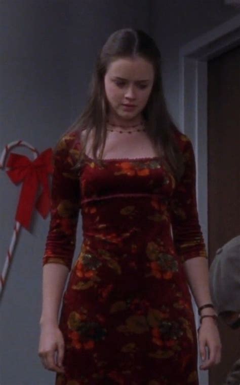 A Woman In A Red Floral Dress Standing Next To A Door