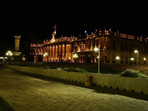 An Old Building Lit Up At Night With Street Lights