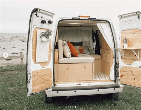The Back End Of An Old Camper Van With Its Doors Open And Pillows In It