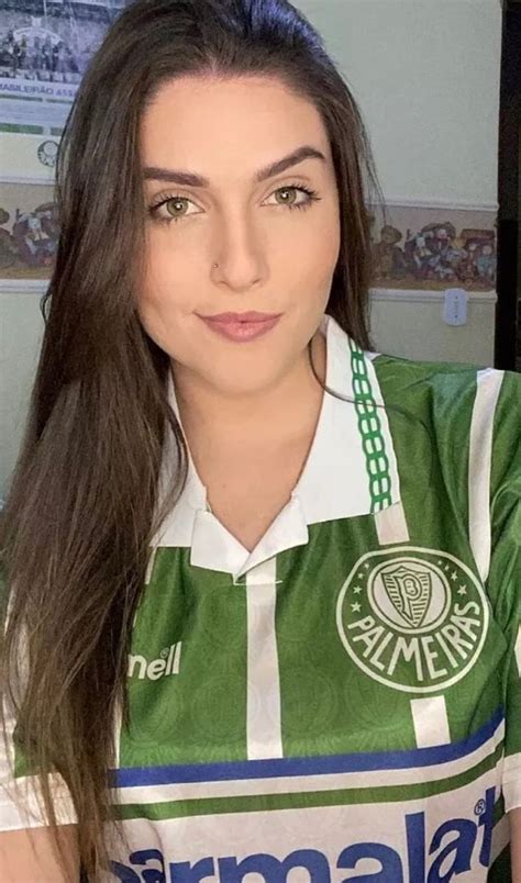 A Woman With Long Brown Hair Wearing A Green And White Soccer Jersey