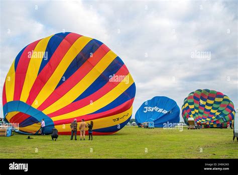 Three Hot Air Balloons On The Ground Being Prepared For Flight With A