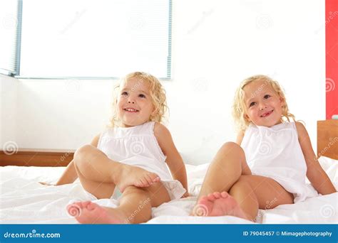 Deux Belles Petites Filles Posant Sur Le Lit Image Stock Image Du