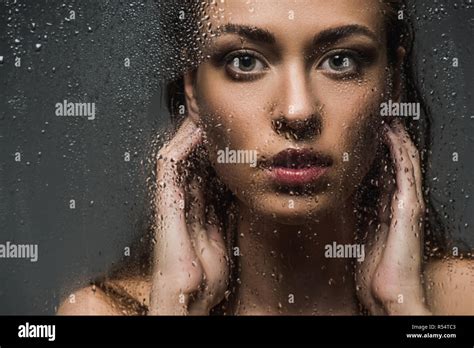Beautiful Brunette Woman Behind Wet Glass With Drops Stock Photo Alamy
