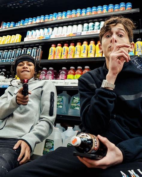 Two People Sitting In Front Of A Store Shelf With Drinks And Sodas